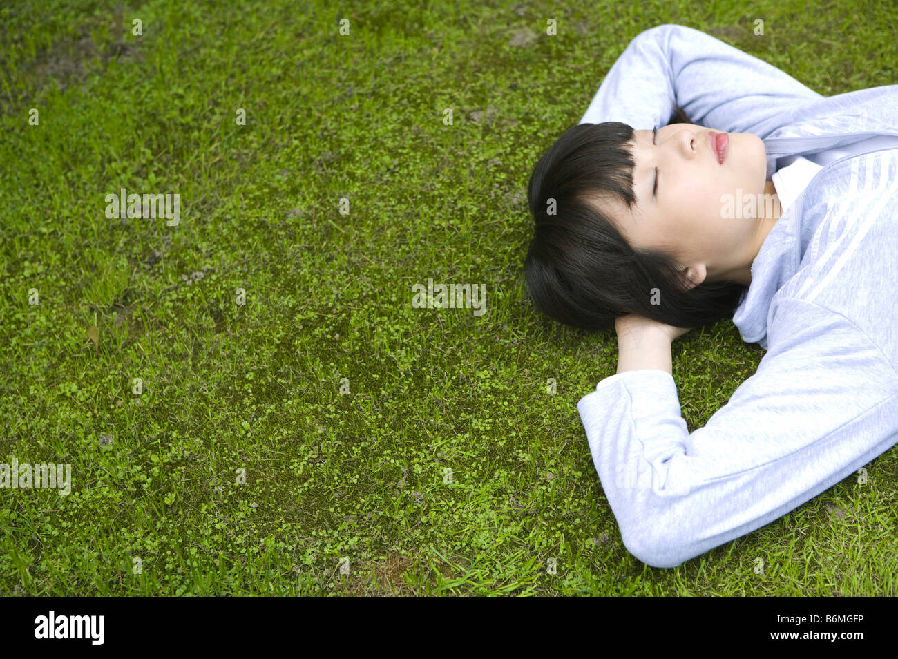Young woman lying on lawn sleeping Stock Photo - Alamy