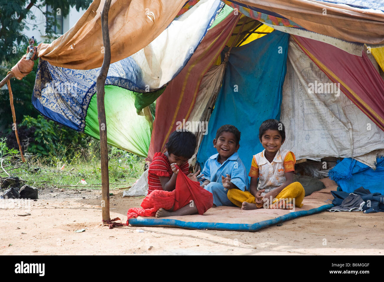 Happy poor indian children sitting outside their tent home. Andhra ...