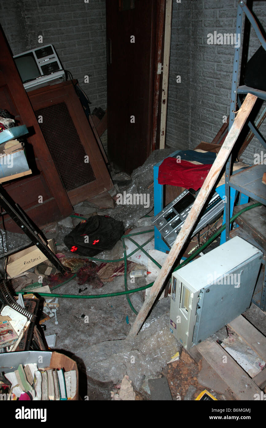 Trash and junk in dirt floor basement covered in dust and deteriorating ...