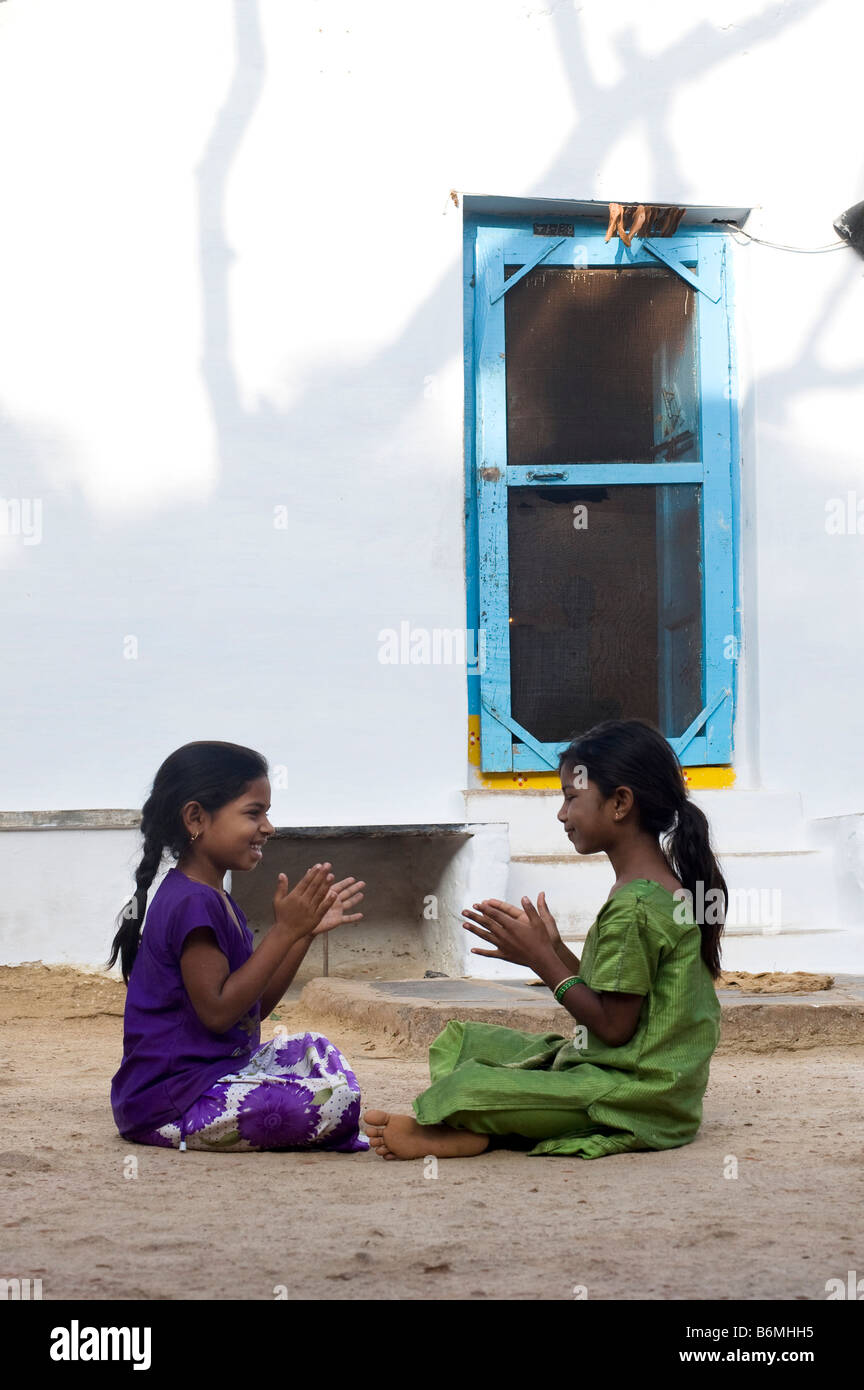 Young Indian village girls playing a hand clapping game outside a rural ...