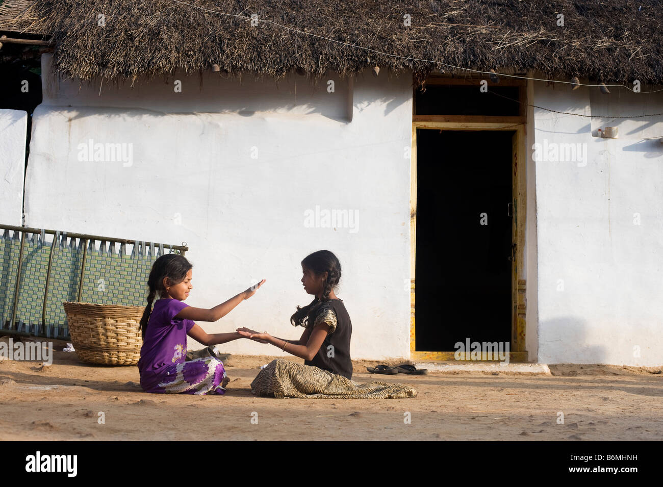 Young Indian village girls playing a hand clapping game outside a rural ...