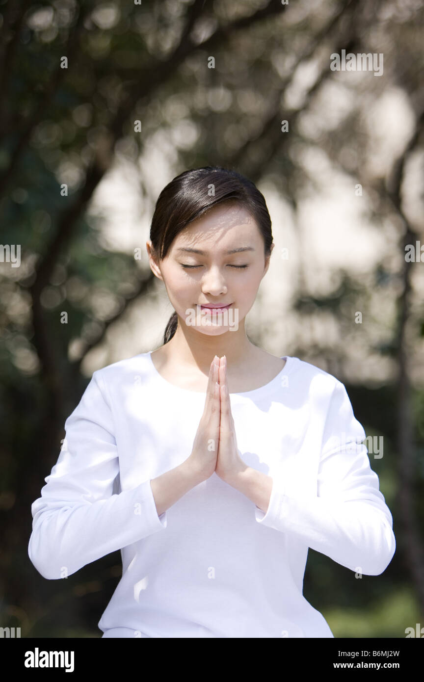 Young woman in praying position Stock Photo - Alamy