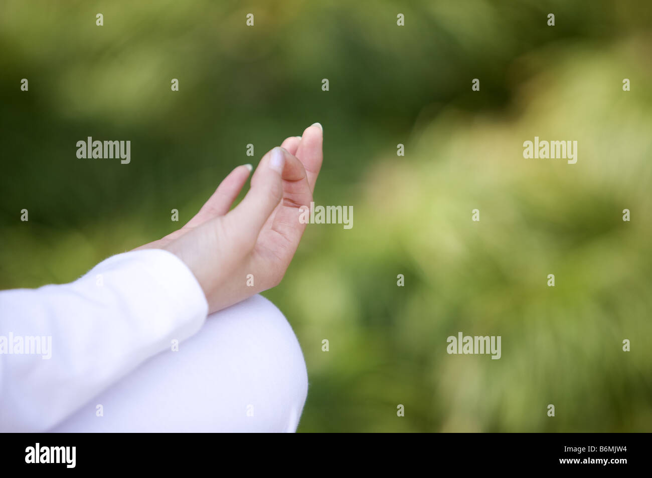 Woman in lotus position focus on hand and leg Stock Photo - Alamy