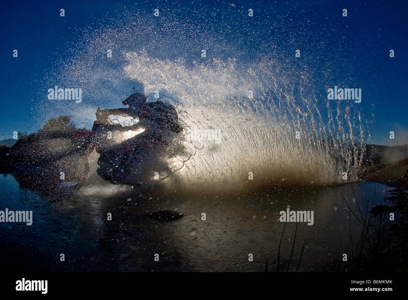 motorcycle rider splashing across stream in Central Nevada Stock Photo ...