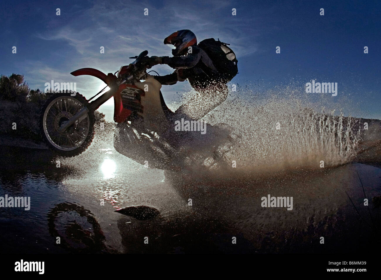 motorcycle rider splashing across stream in Central Nevada Stock Photo ...