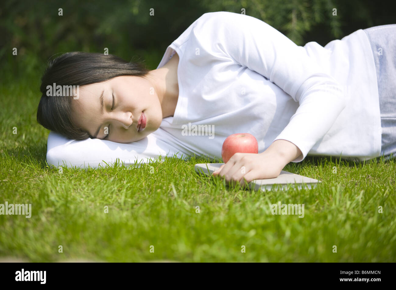 Young woman lying on lawn napping outdoors Stock Photo - Alamy