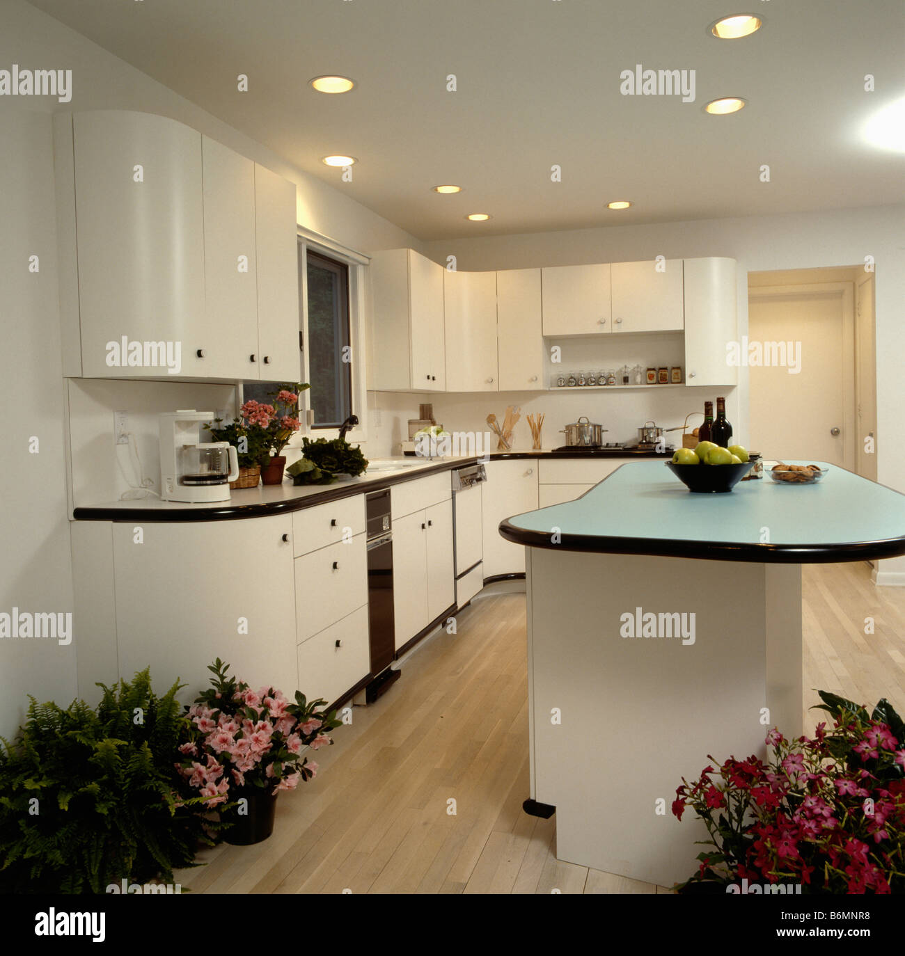 Downlighting and curved island unit with pale blue worktop in modern ...