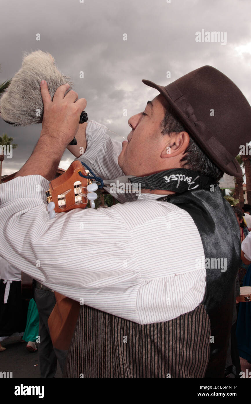 A reveller in traditional dress drinks from a goatskin flask at the ...