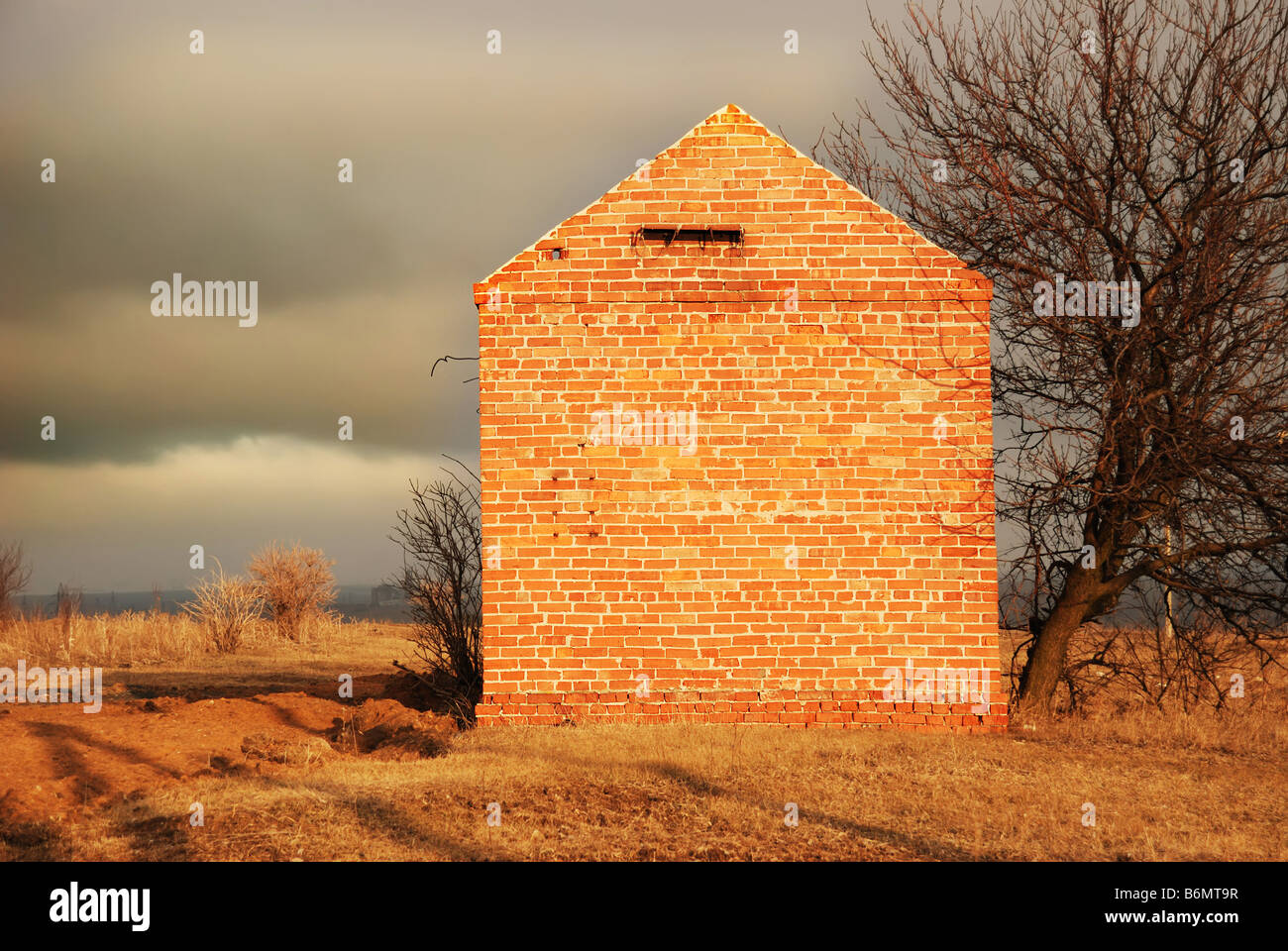 Brick building The storm sky and an old tree Stock Photo - Alamy