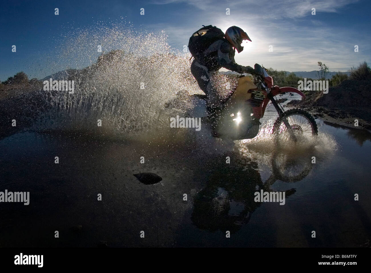 motorcycle rider splashing across stream in Central Nevada Stock Photo ...