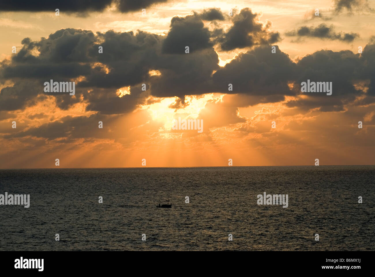 Sun breaking through early morning clouds Stock Photo - Alamy