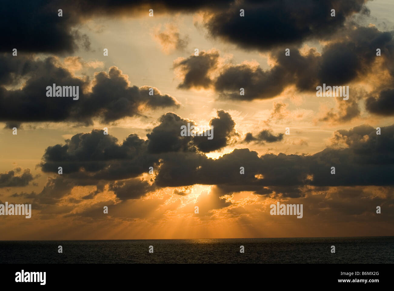 Sun breaking through early morning clouds Stock Photo - Alamy