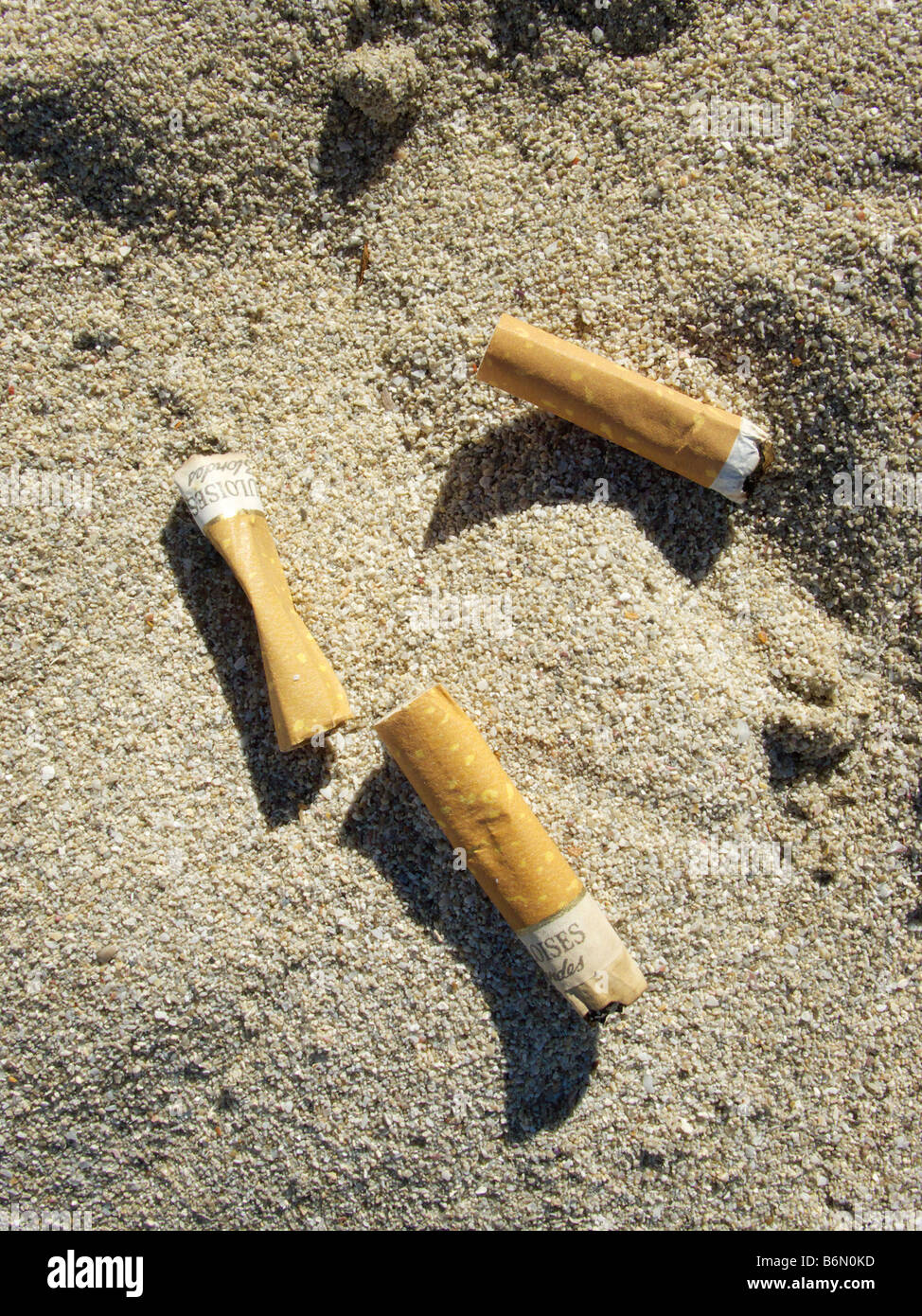 Discarded cigarette ends on a beach Stock Photo - Alamy