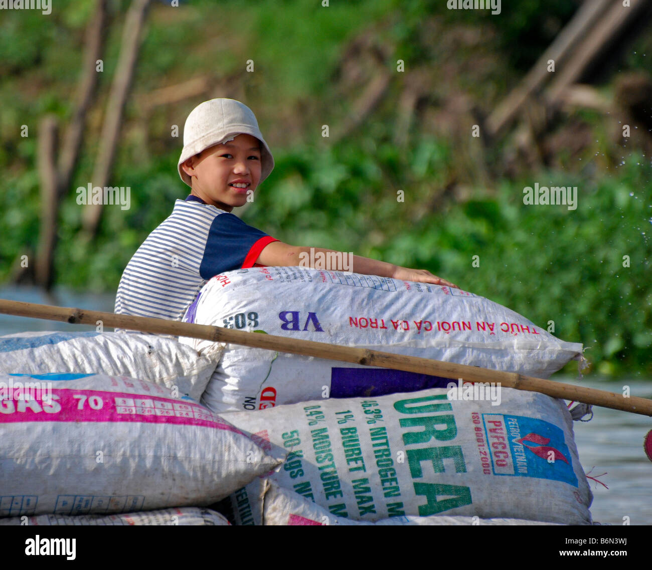 Young boy on sampan carrying fertiliser, Mekong Delta, Vietnam Stock ...