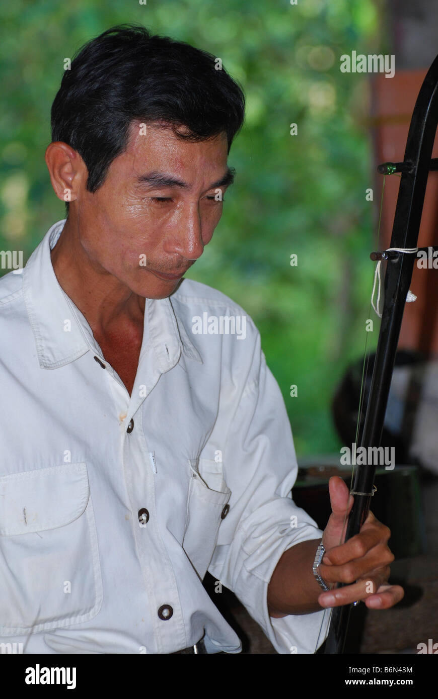 Musician playing the Vietnamese dan bau (one-stringed zither Stock ...