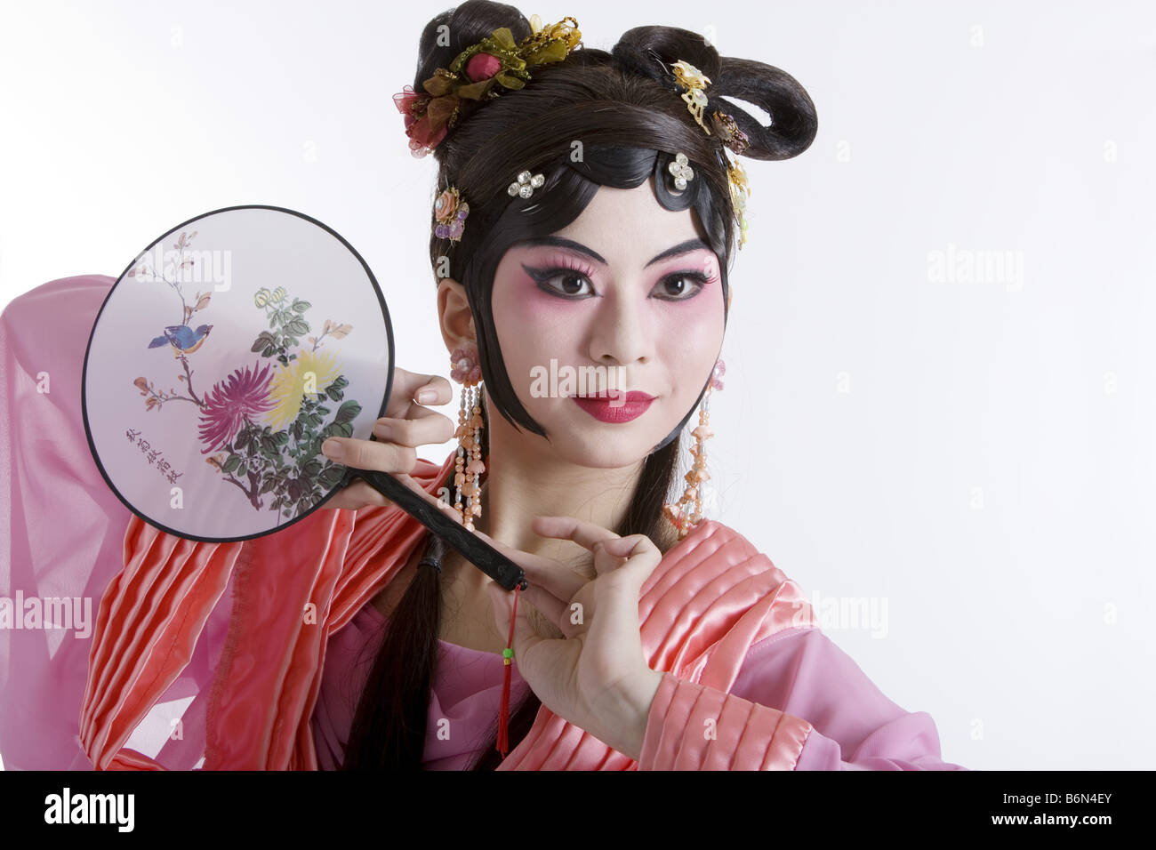 Mature woman wearing traditional clothing holding fan Stock Photo - Alamy