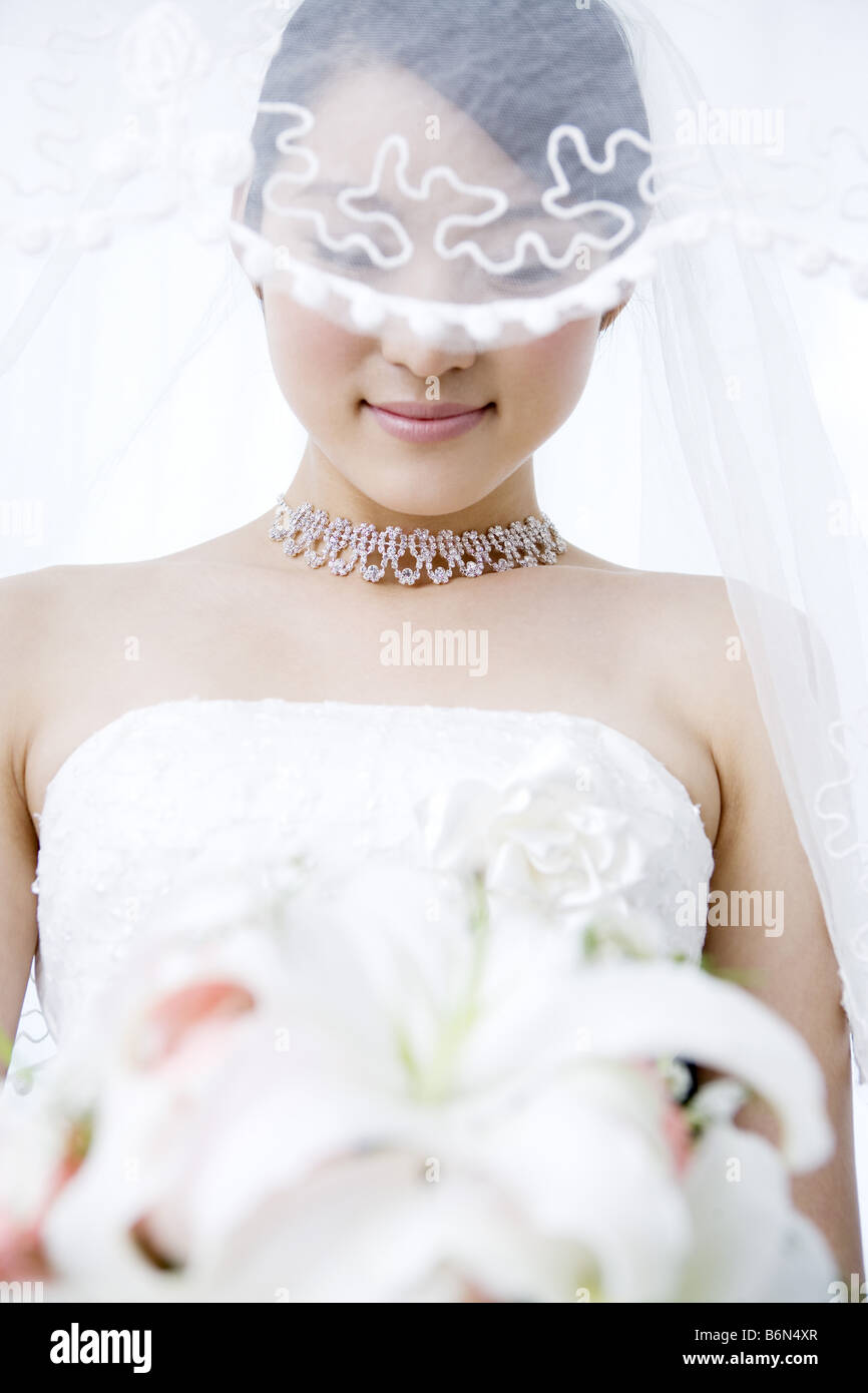 Young bride with veil covering her face Stock Photo - Alamy