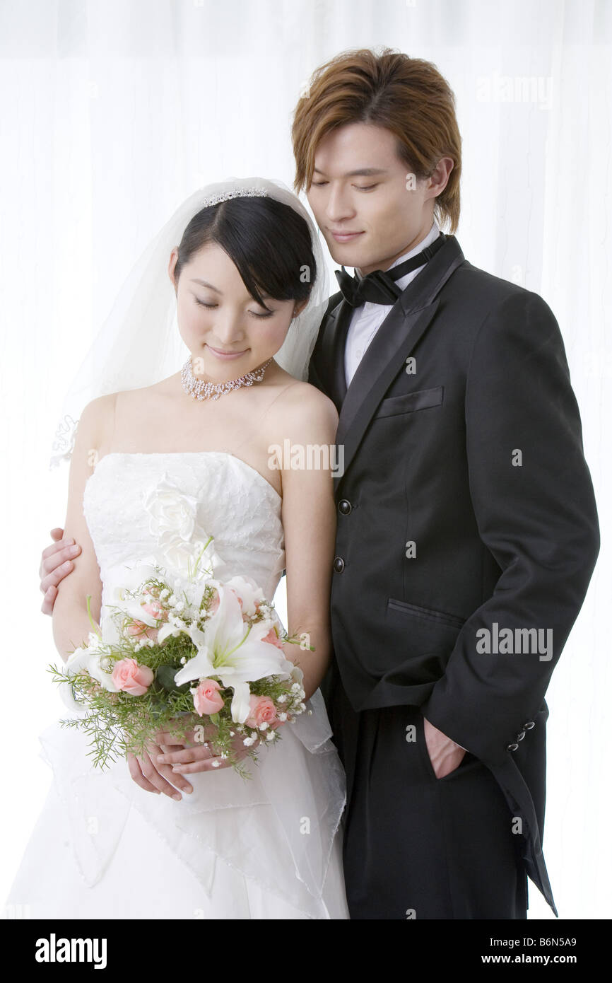 Young newlywed couple embracing side view portrait Stock Photo - Alamy