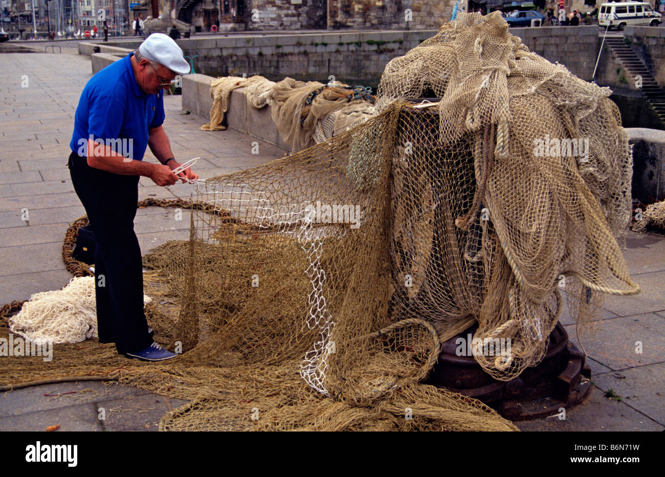 Fisherman mending nets in the harbour at Honfleur Stock Photo - Alamy