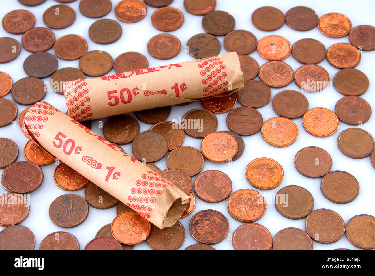 Concept of paper coin rollers amoung pennies on white background ...