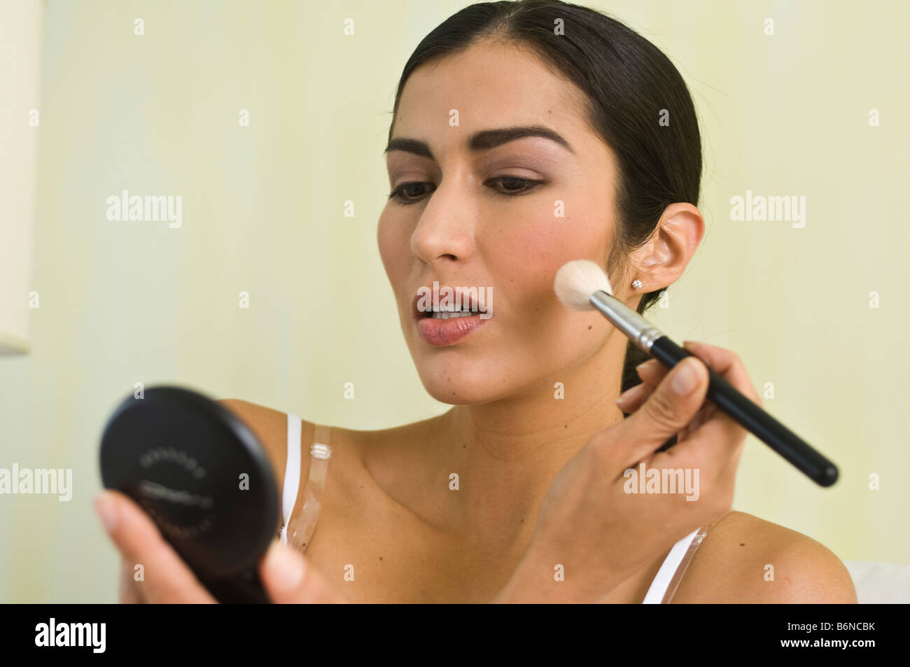Young woman putting on make-up Stock Photo - Alamy