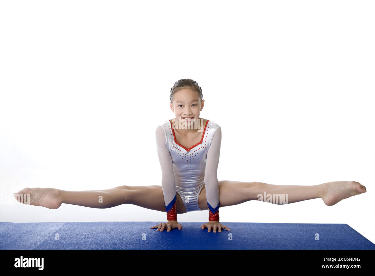 Girl practicing gymnastic pose on pad Stock Photo - Alamy