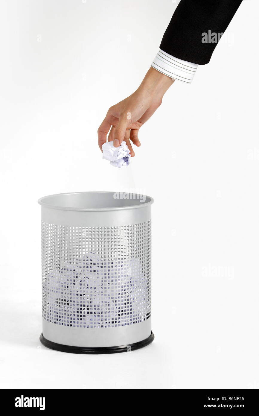 Man throwing paper in waste paper bin close up of hand Stock Photo - Alamy