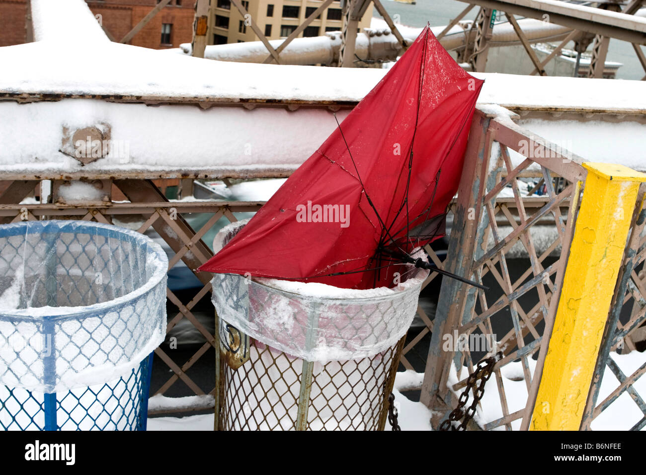 A broken umbrella is abandoned in a garbage can after a snowstorm in ...
