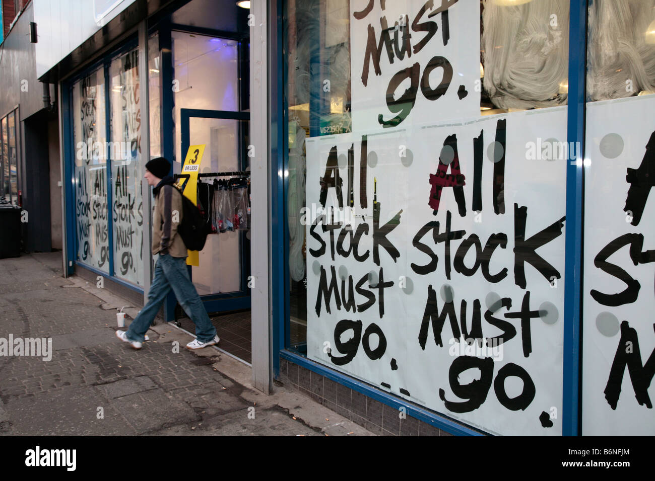 young man leaving a shop empty handed with all stock must go signs in ...