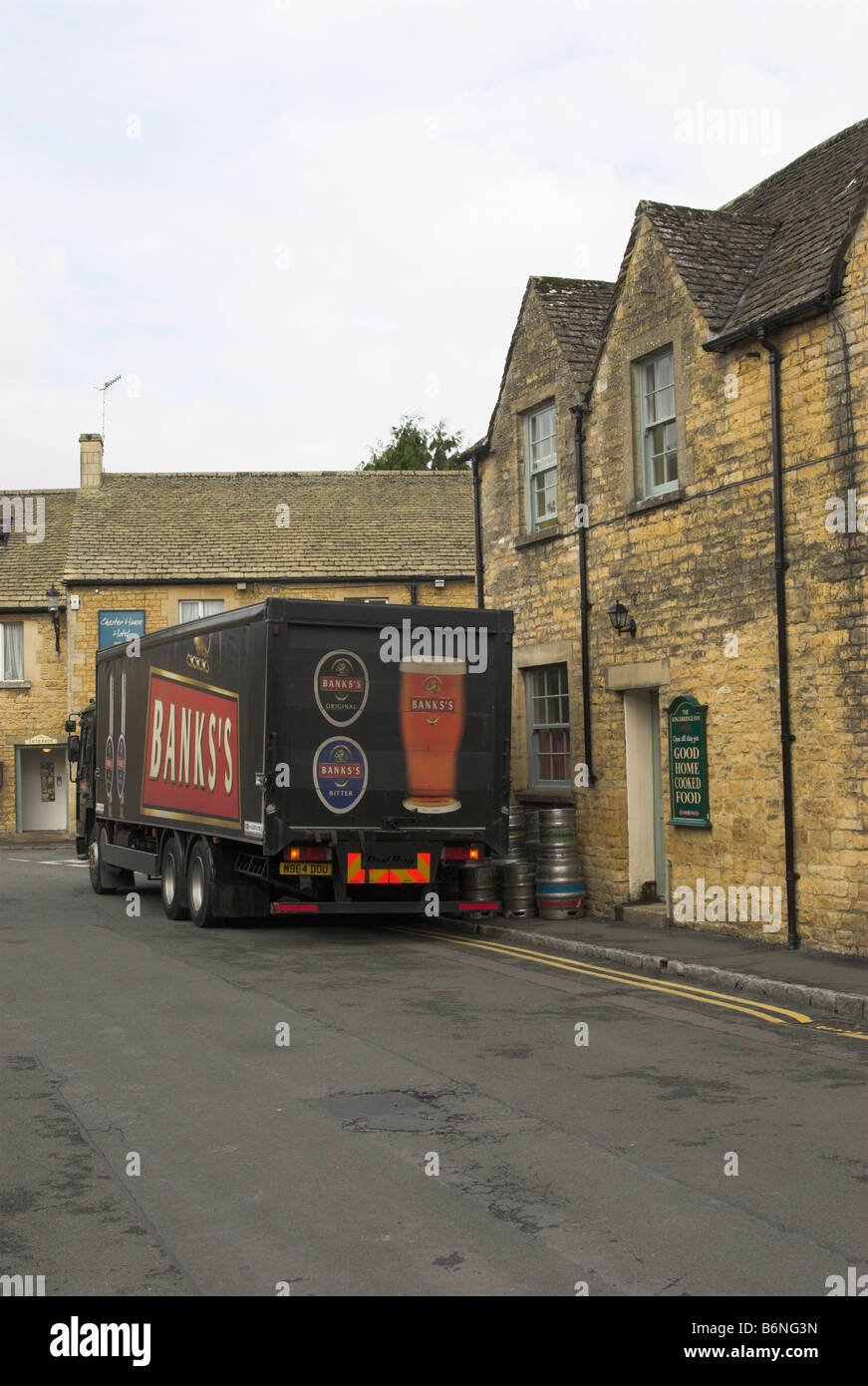 A Brewers dray unloading barrels of beer at a Cotswold pub Stock Photo ...