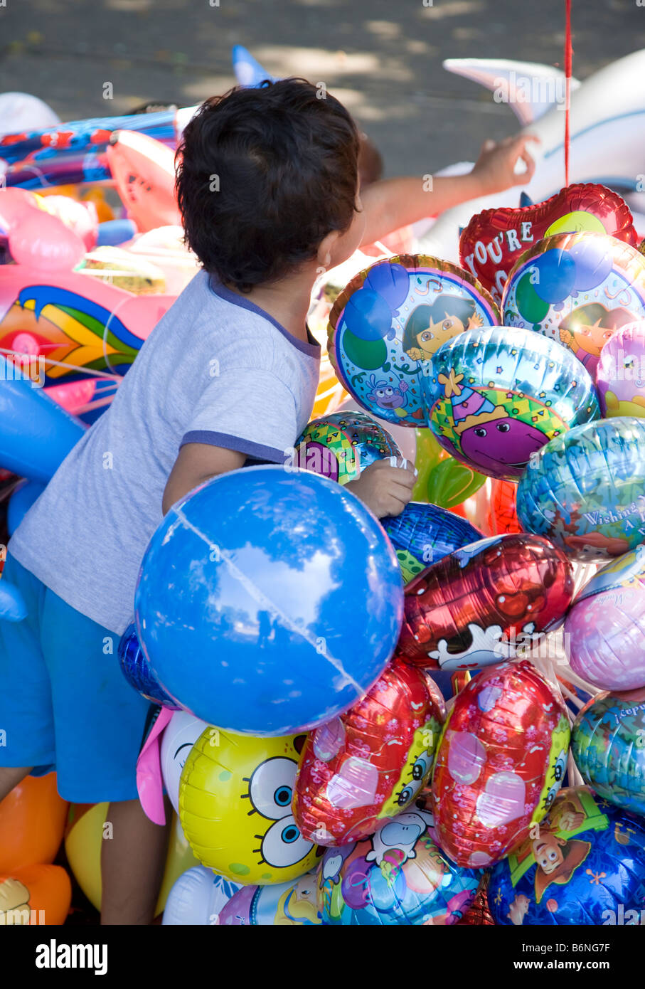 Boy reaching for coloured balloons Plaza del Independencia Merida ...