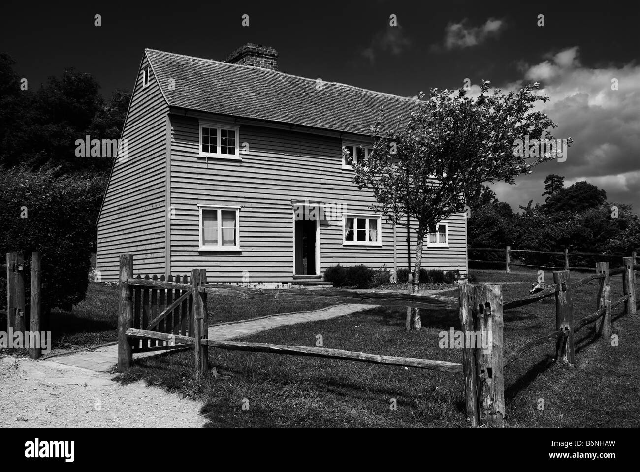 Farm House in fenced of paddock with a lone tree in the front garden ...