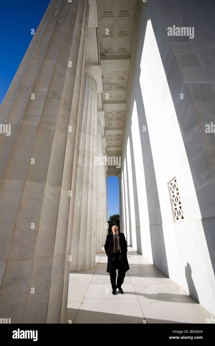 A man walks along the exterior wall and columns Stock Photo - Alamy