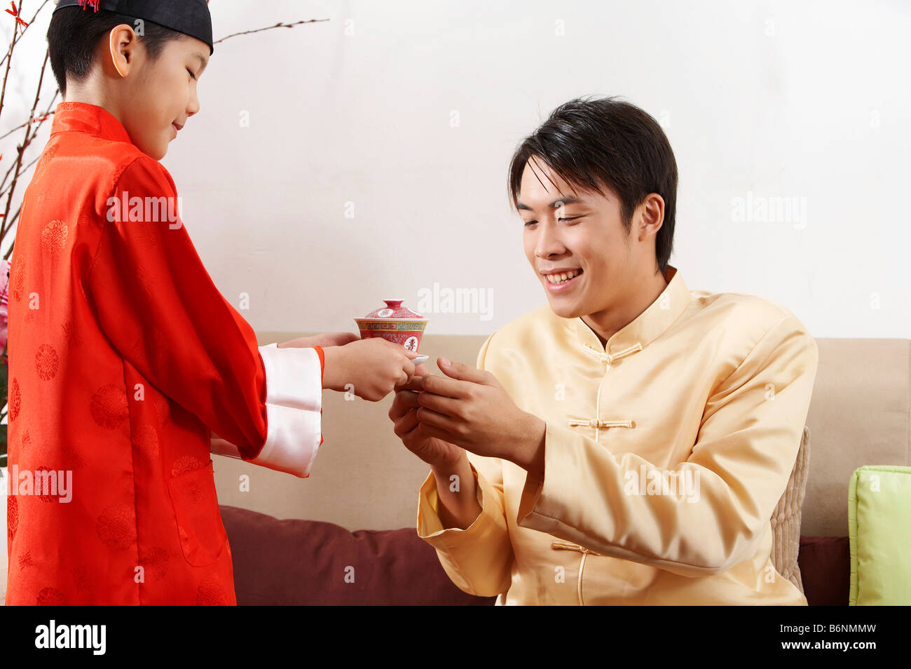 son bringing his father a cup of chinese tea Stock Photo - Alamy