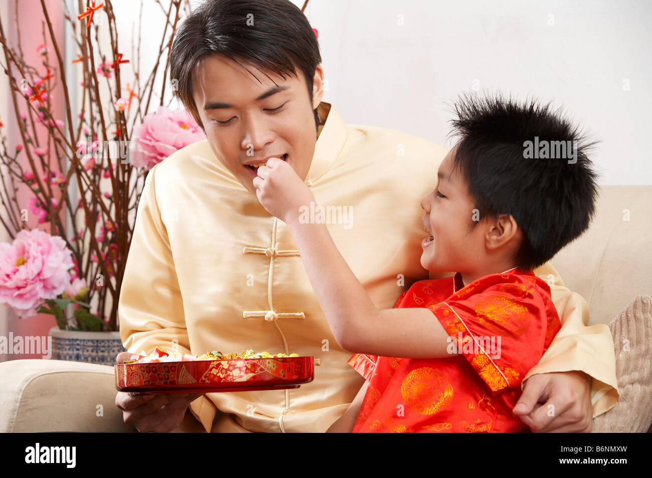 boy feeding candy to man Stock Photo - Alamy