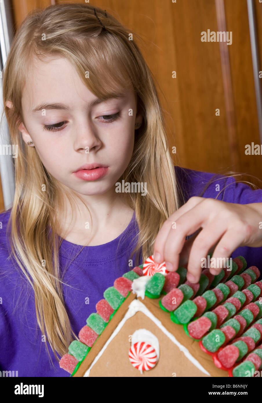 Child placing a gumdrop on a gingerbread house Stock Photo - Alamy