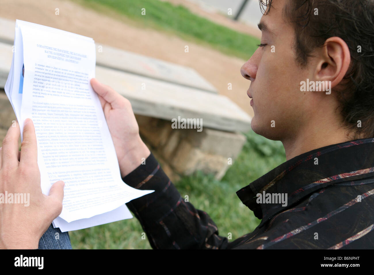 profile of young student reading outdoors Stock Photo - Alamy