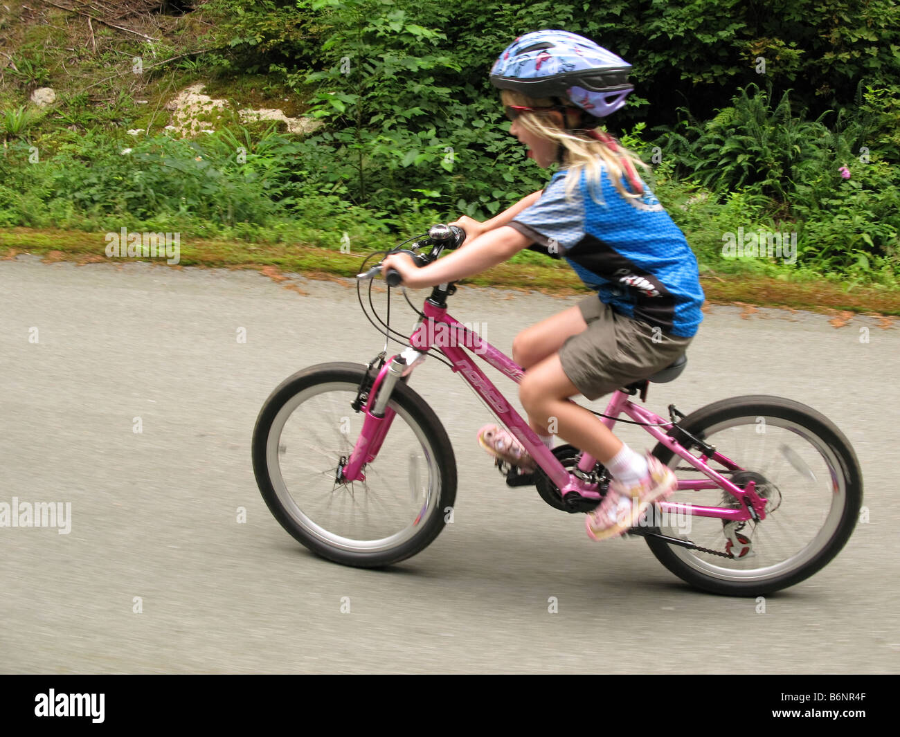 Young girl cycling Stock Photo - Alamy