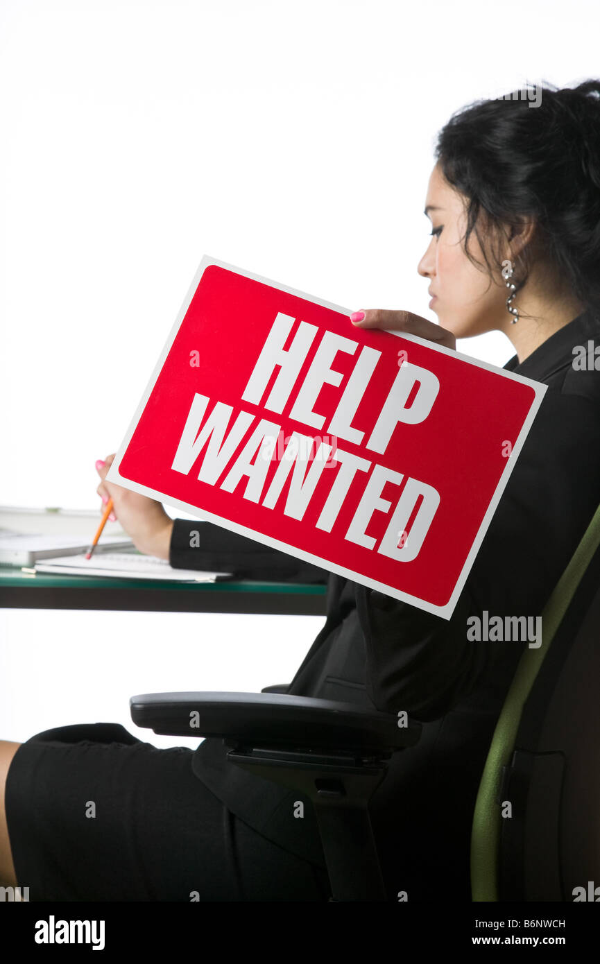 Pretty young businesswoman with a Help Wanted sign Stock Photo - Alamy