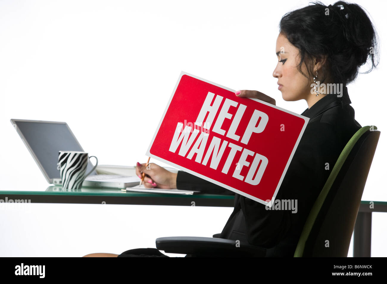 Pretty young businesswoman with a Help Wanted sign Stock Photo - Alamy