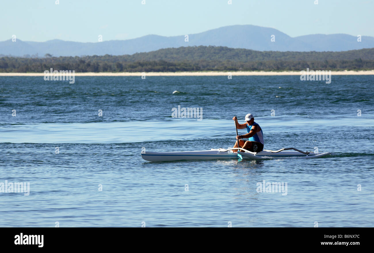 Man in outrigger canoe Stock Photo - Alamy