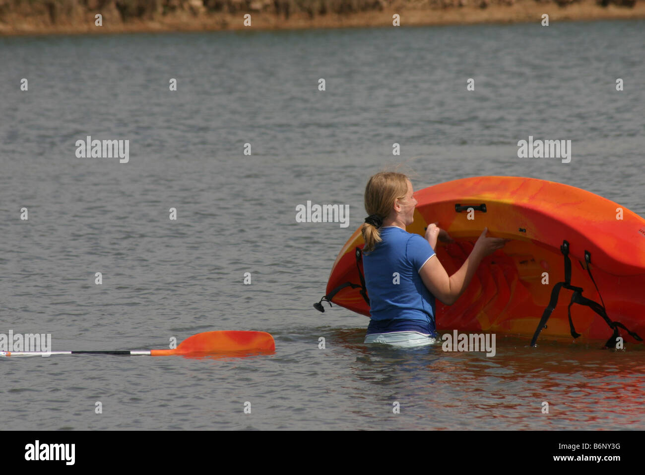 Cute early teen blonde girl righting her kayak Stock Photo - Alamy