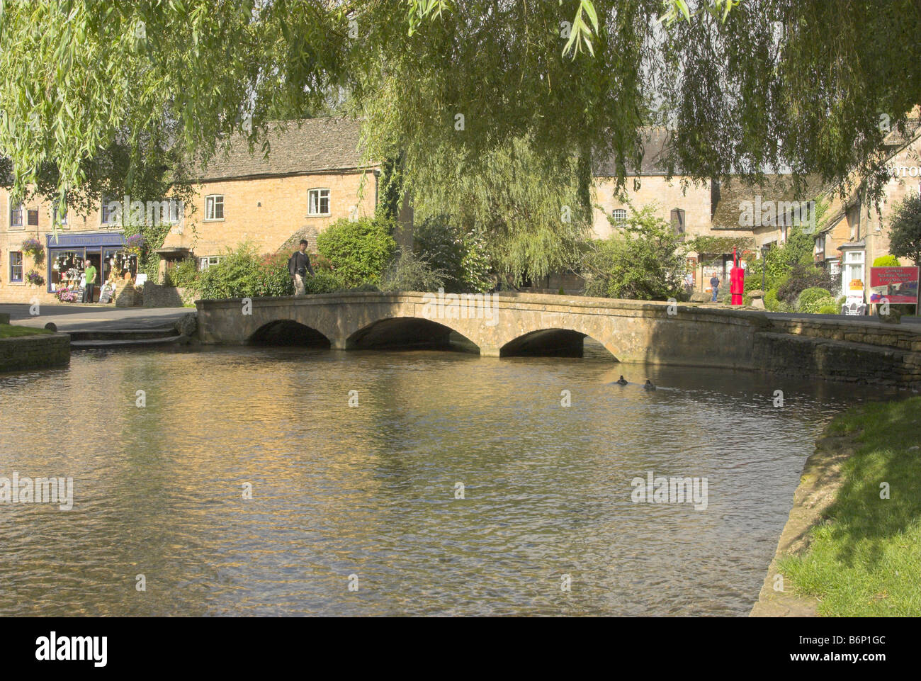 The River Windrush flowing through the picturesque Cotswold village of ...
