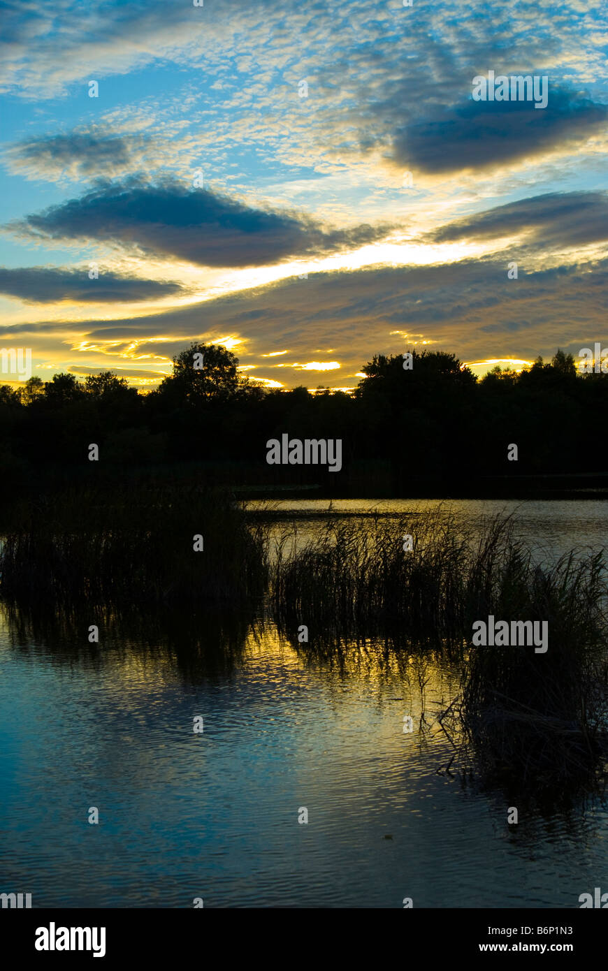 cloudy sunset reflected on water Stock Photo - Alamy