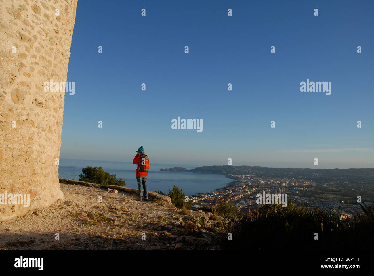 photographer & windmill on La Plana, looking over bay to Cap Prim ...
