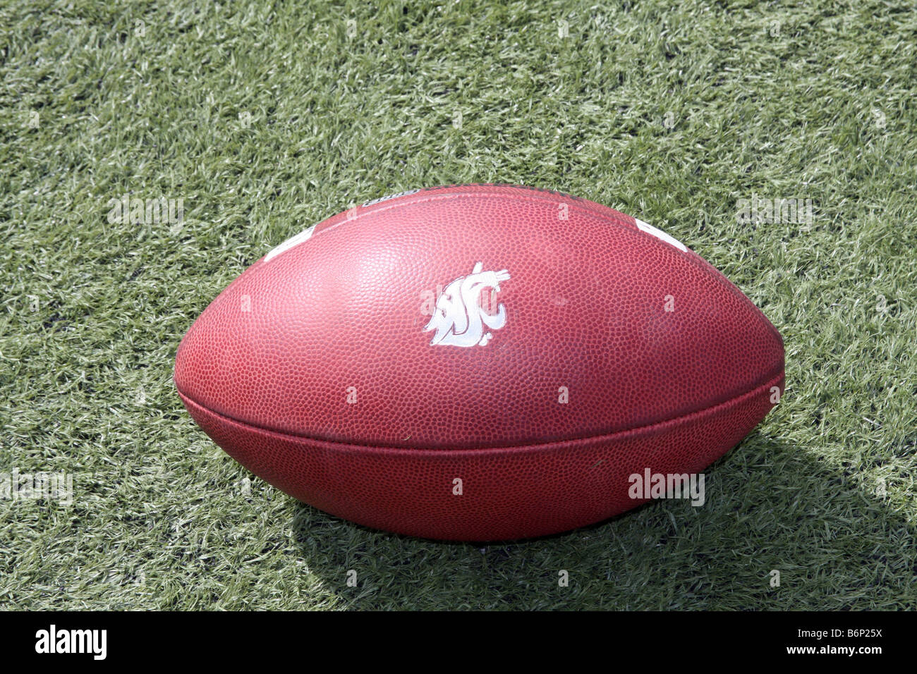 A football casts a shadow on the field turf of a college football ...