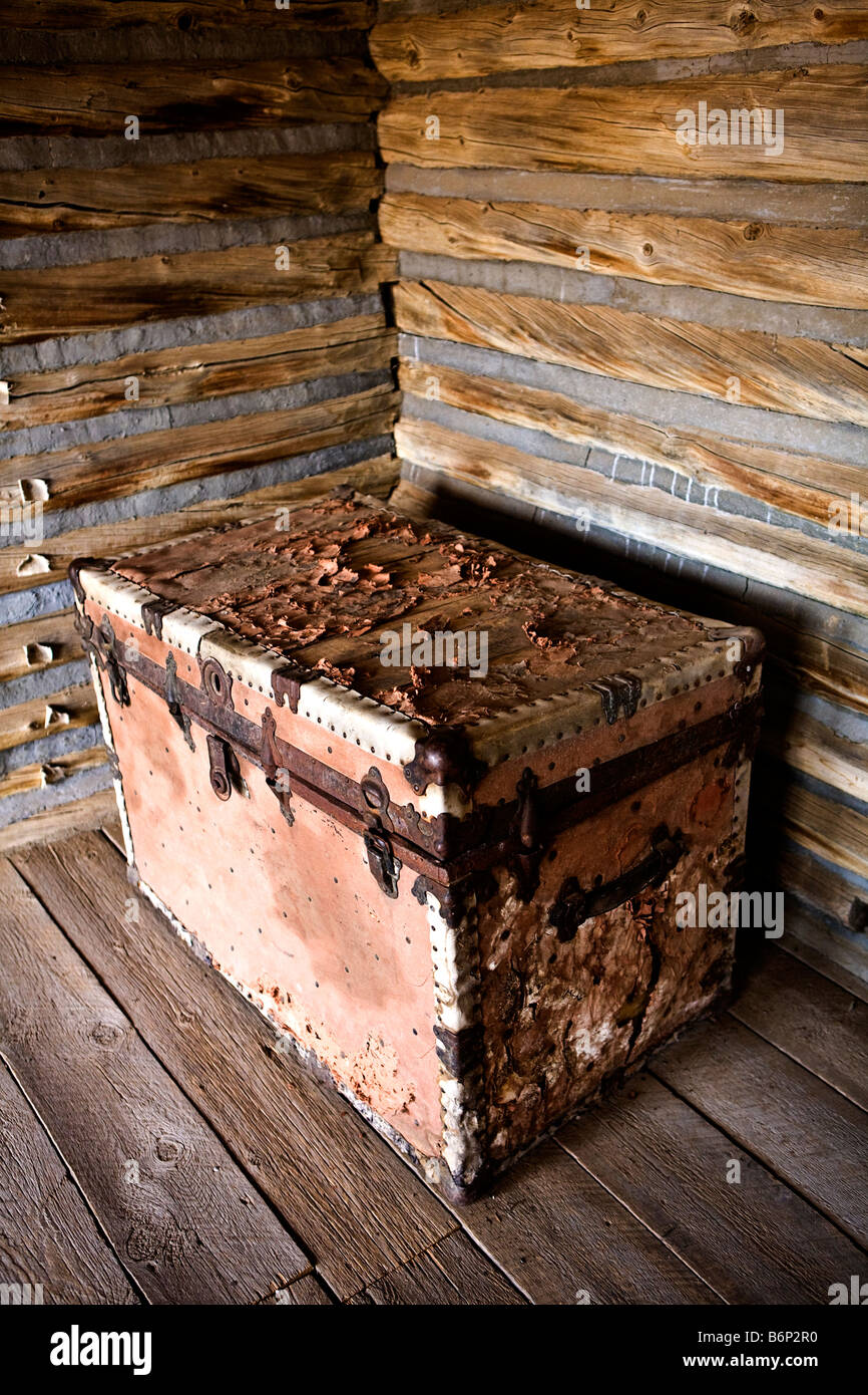 Image of an antique rusted chest sitting on the floor of a log cabin ...