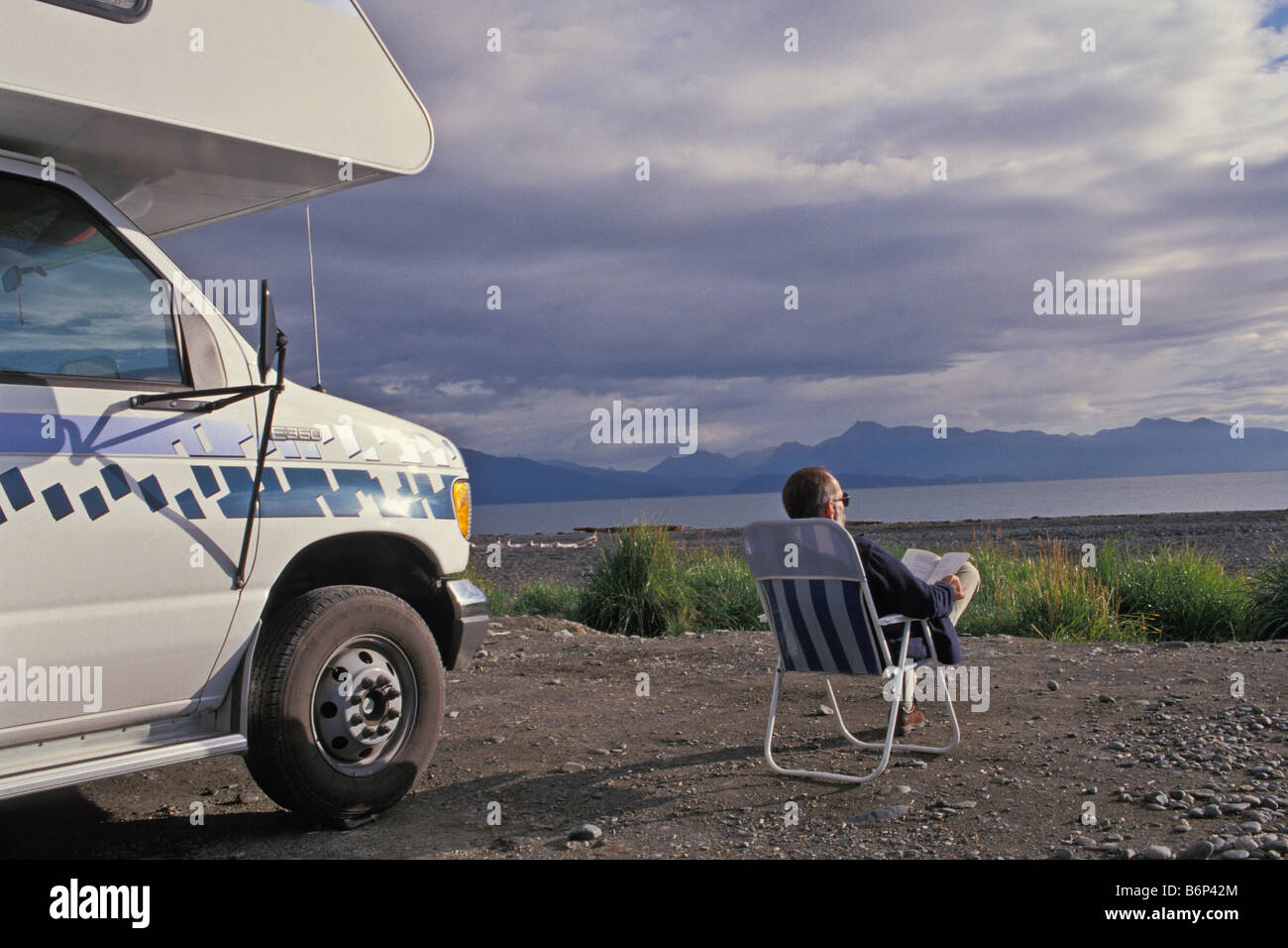 Camper relaxing on beach next to RV on Homer Spit Kachemak Bay Kenai ...
