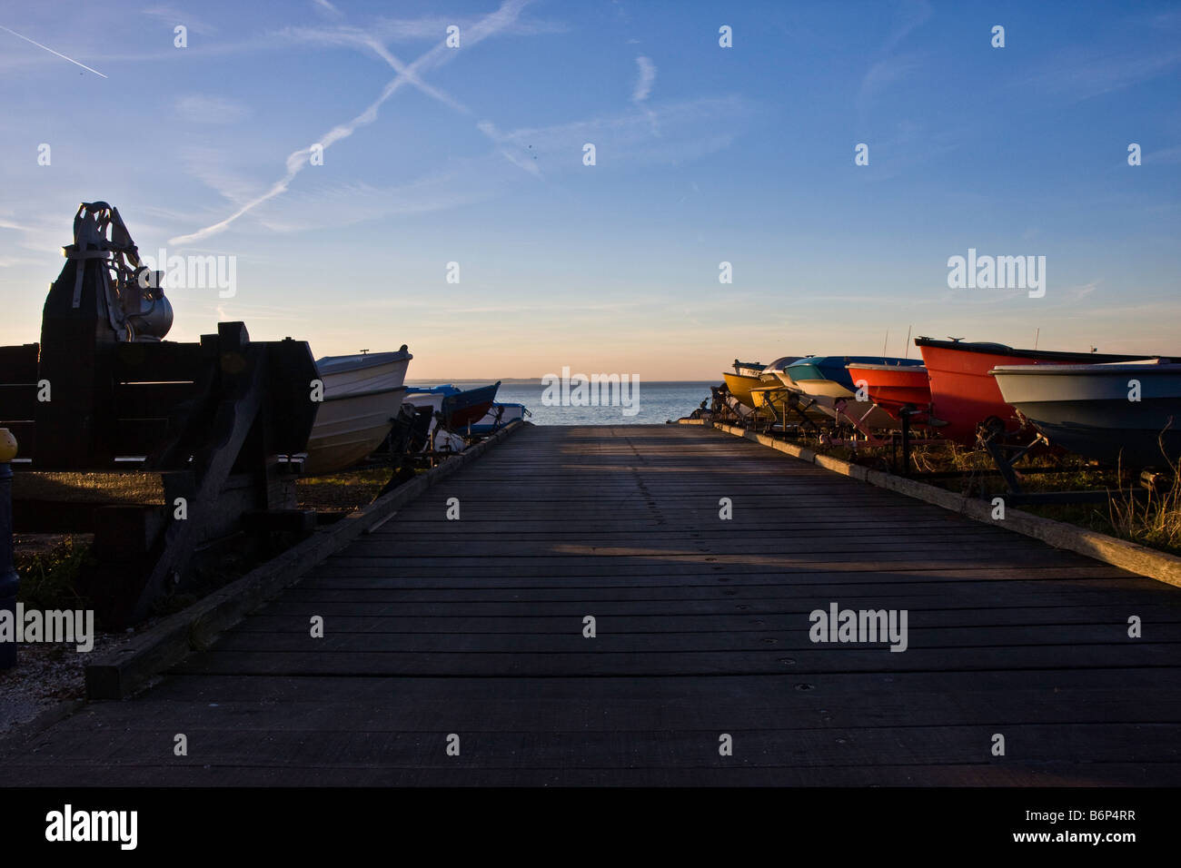 View of the sunset through the boats on the Whitstable slipway Stock ...