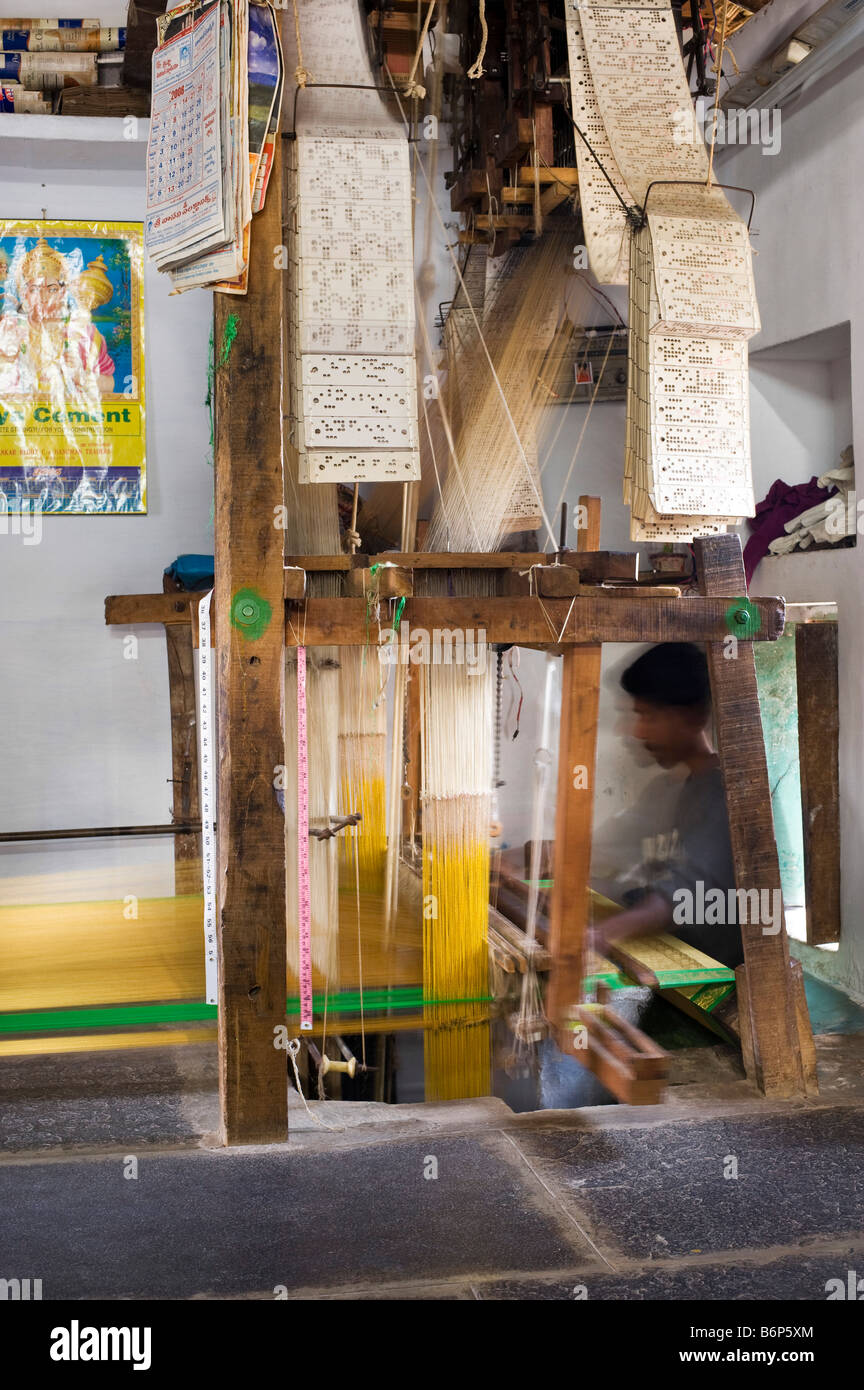 Indian man working a hand loom making a silk sari in an Indian cottage ...